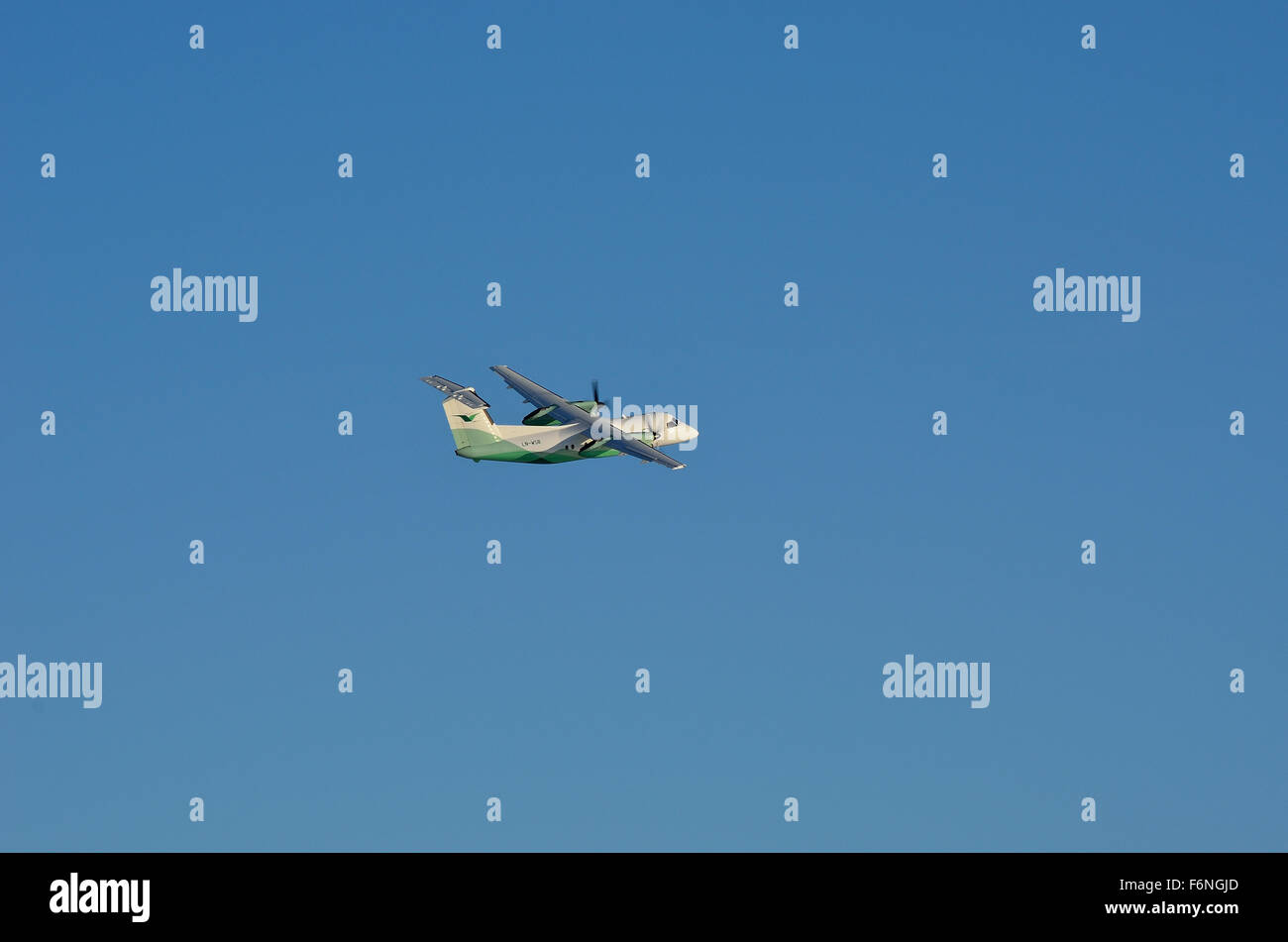 green and white propeller aircraft climbing on blue sunny sky after ...