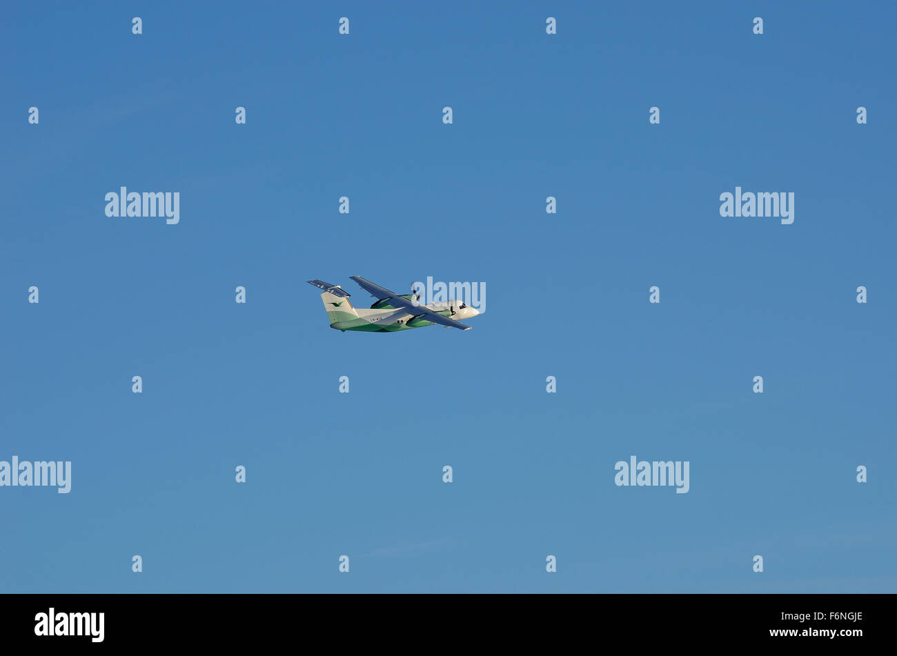 green and white propeller aircraft climbing on blue sunny sky after ...
