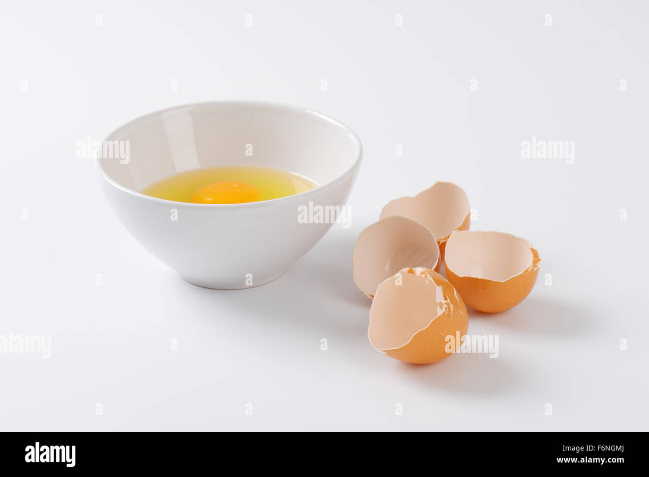 bowl of raw eggs and egg shells on white background Stock Photo - Alamy