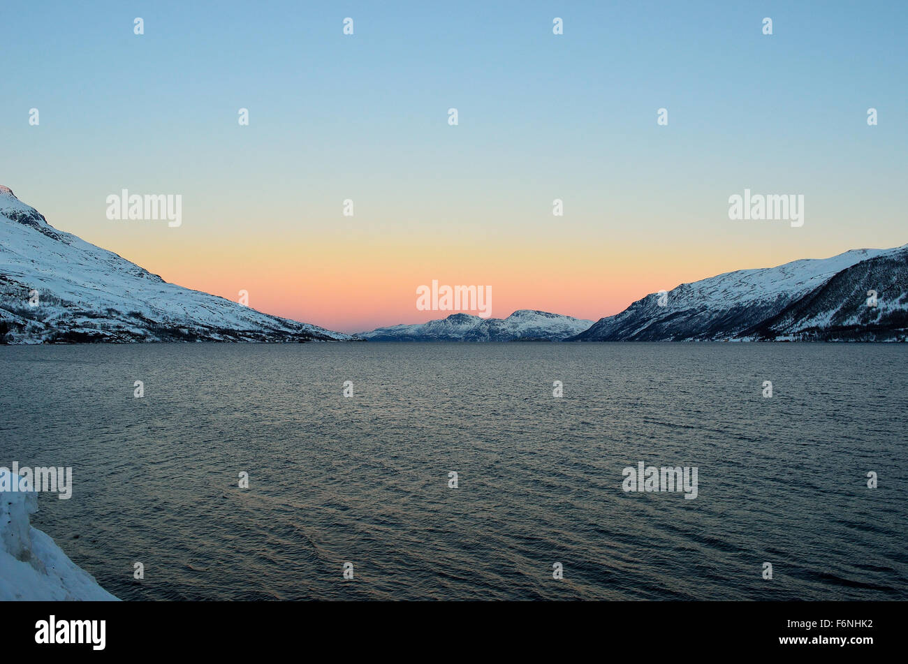 Vibrant colours on dawn sky over cold arctic fjord water and majestic ...