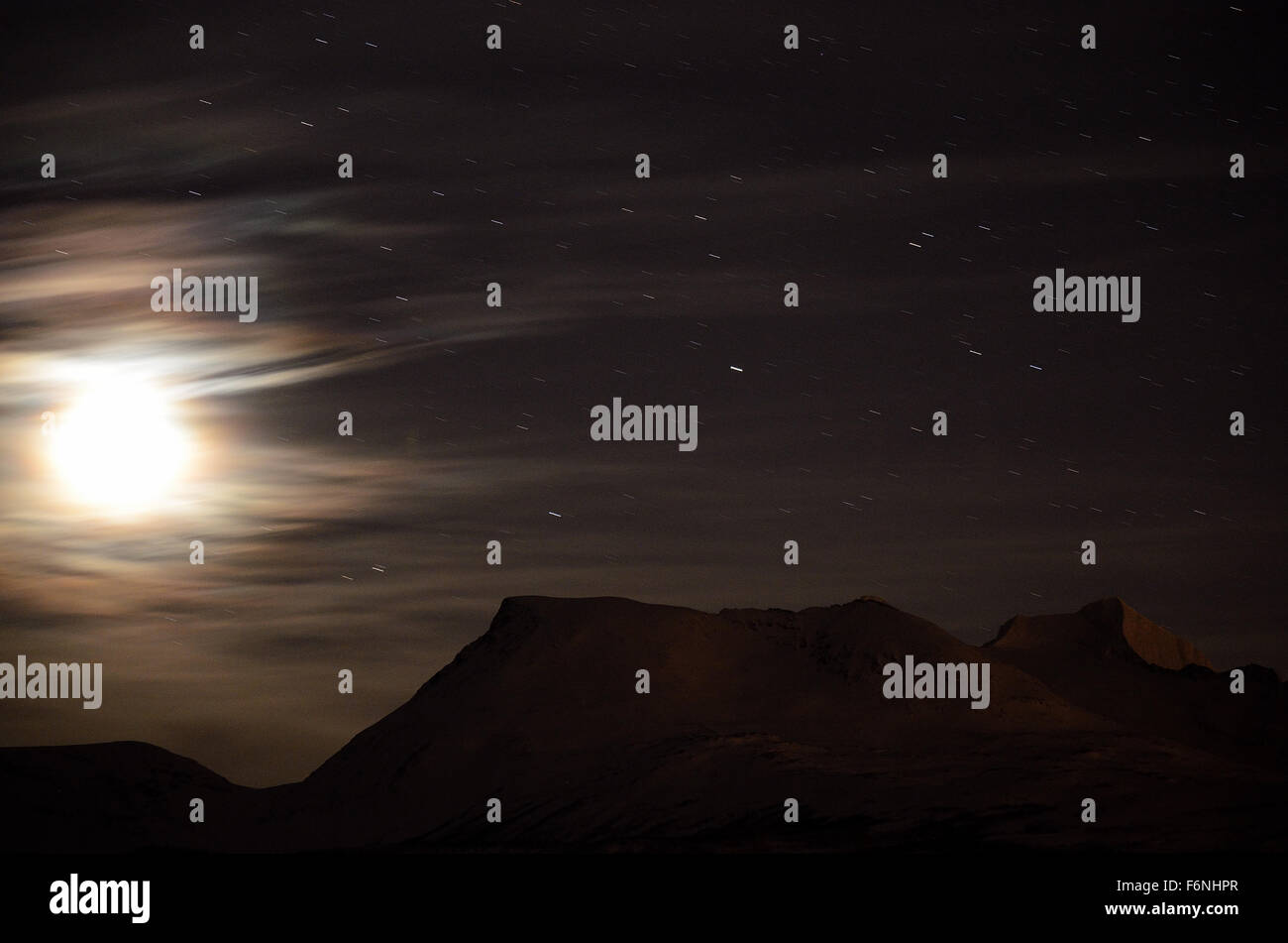 full moon on hazy winter night sky over snowy mountain peak Stock Photo ...