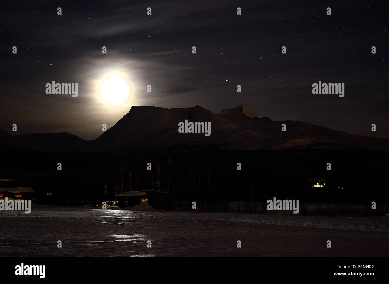 full moon on hazy winter night sky over snowy mountain peak Stock Photo ...