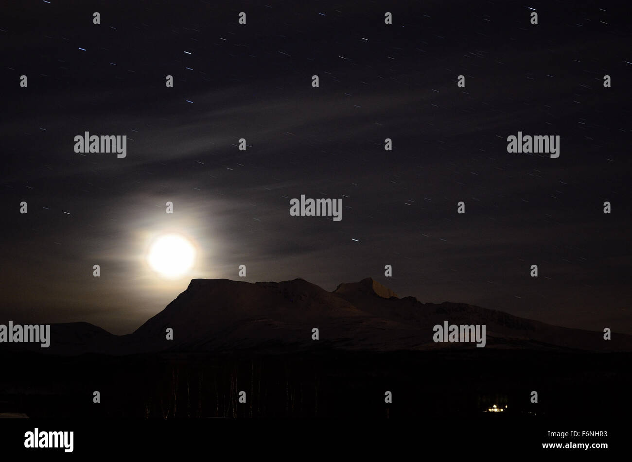 full moon on hazy winter night sky over snowy mountain peak Stock Photo ...