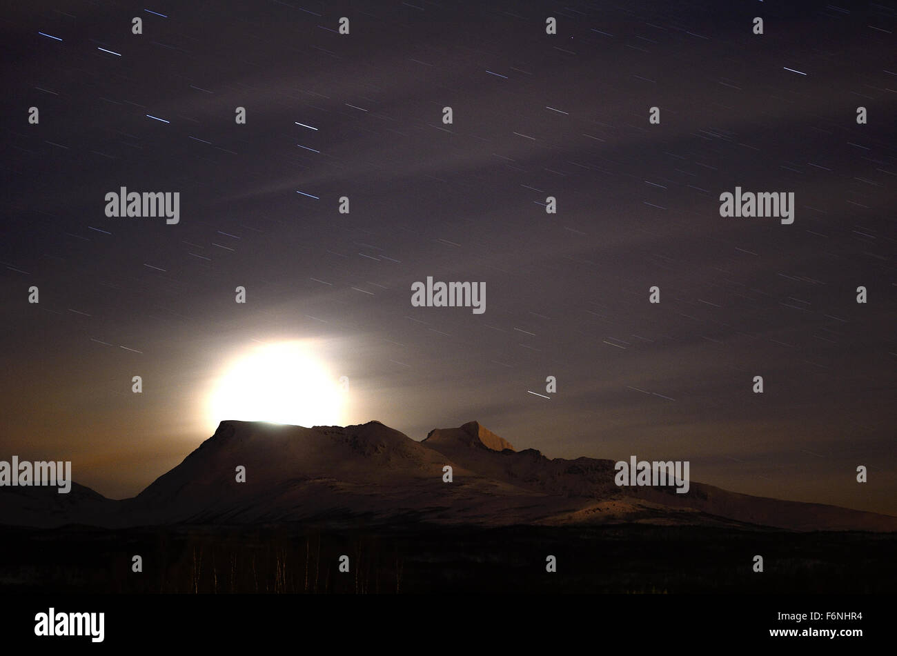 full moon on hazy winter night sky over snowy mountain peak Stock Photo ...