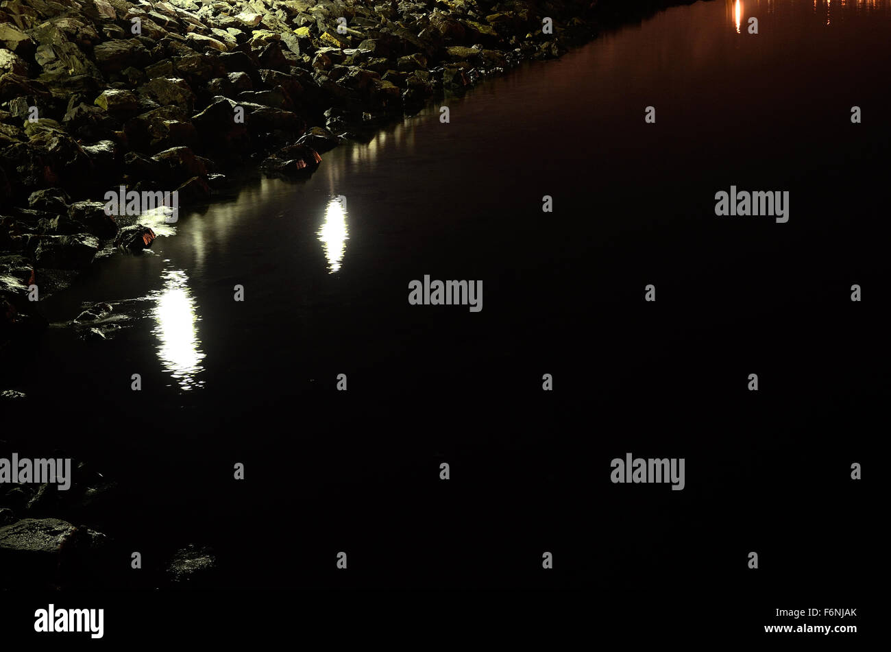 light pole reflection on sea shore surface in night time Stock Photo ...