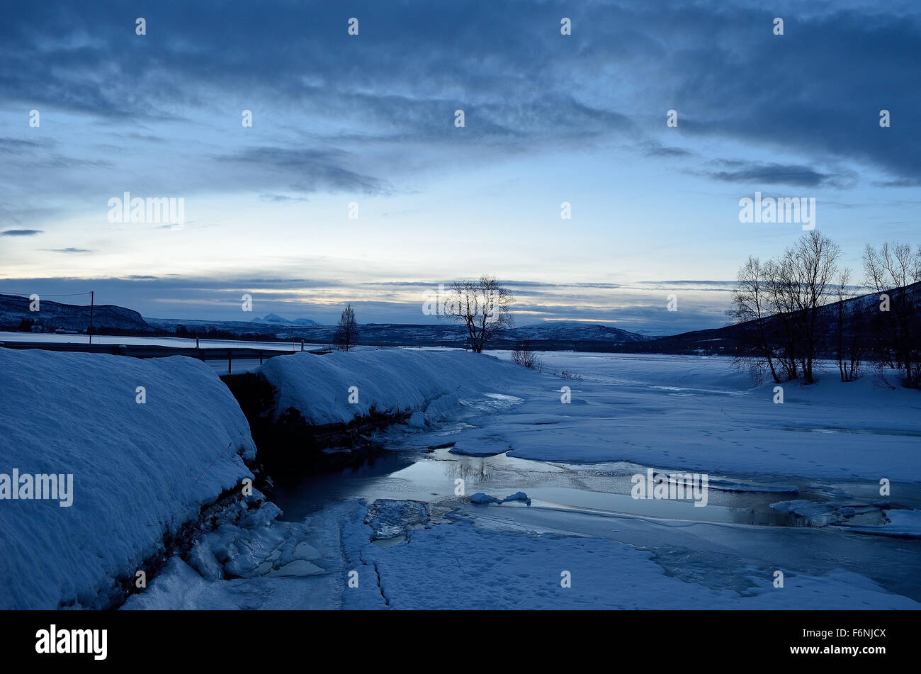icy cold river flow and white snowy field Stock Photo - Alamy