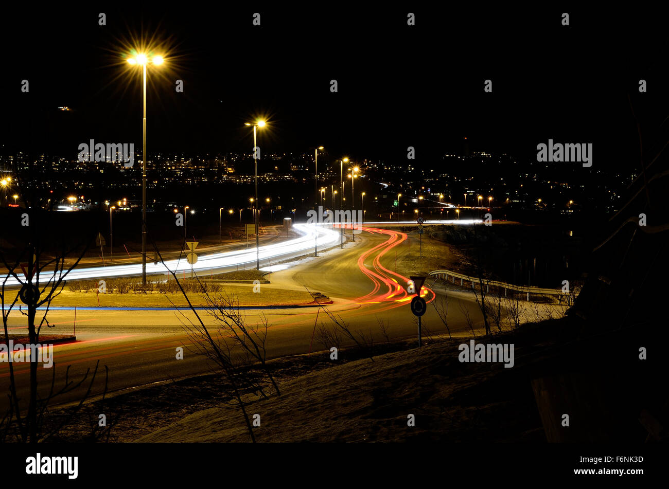 car traffic on road at night time around roundabout Stock Photo - Alamy