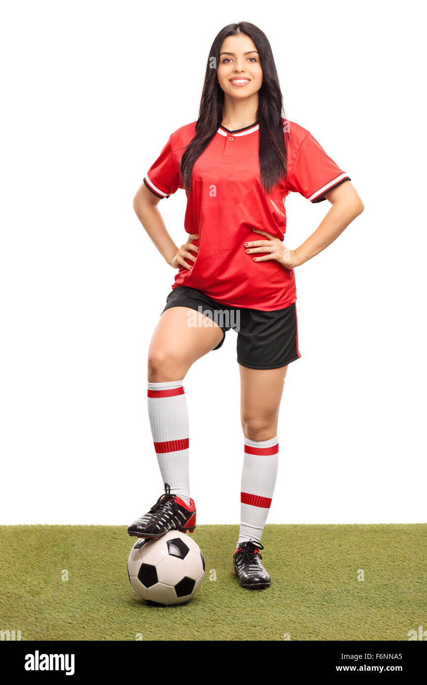 Full length portrait of a young female football player stepping over a ...