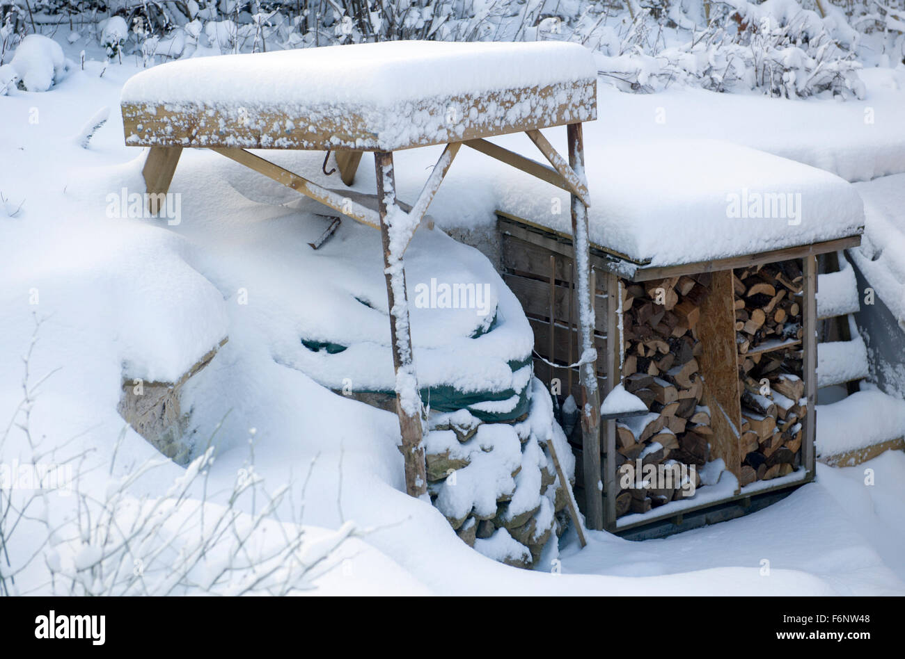 heavy snowfall on a wood store and the cover of an outdoor oven in ...