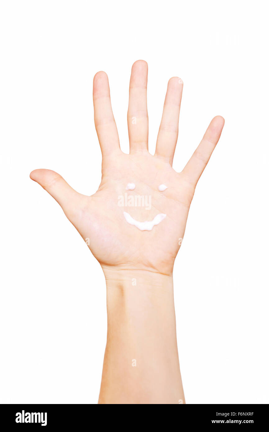 Smile symbol painted hand cream on a female palm. Isolated on white ...