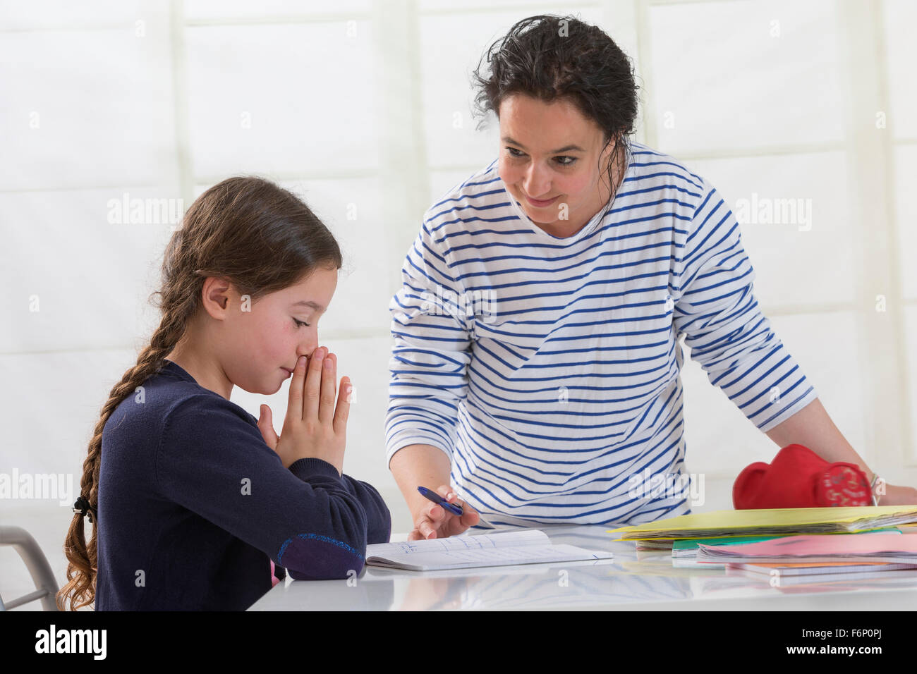 Mom helping her daughter do homework Stock Photo - Alamy