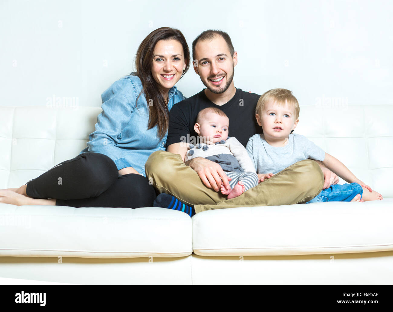 Young happy family with two children at home Stock Photo - Alamy