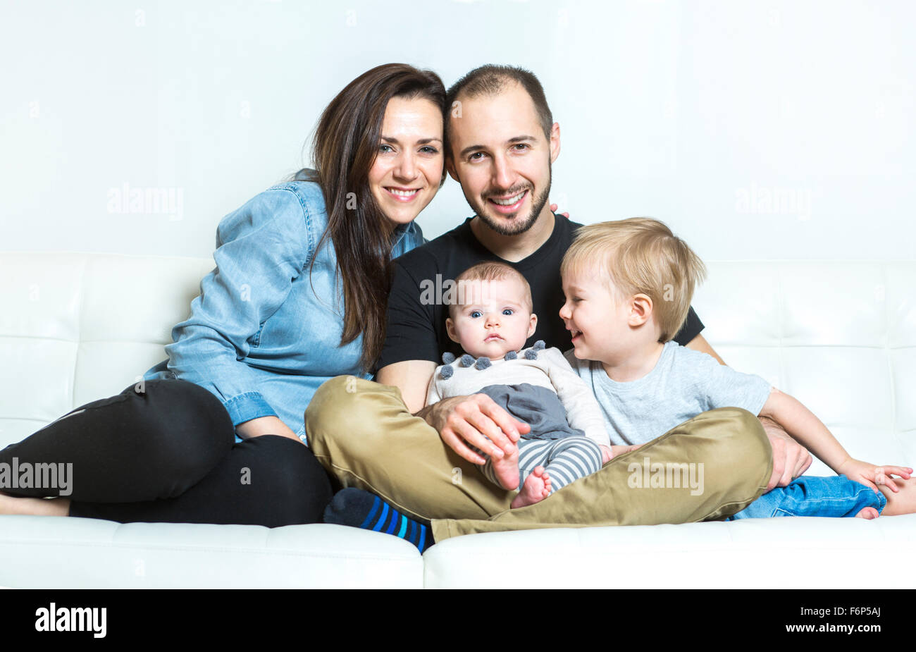 Young happy family with two children at home Stock Photo - Alamy