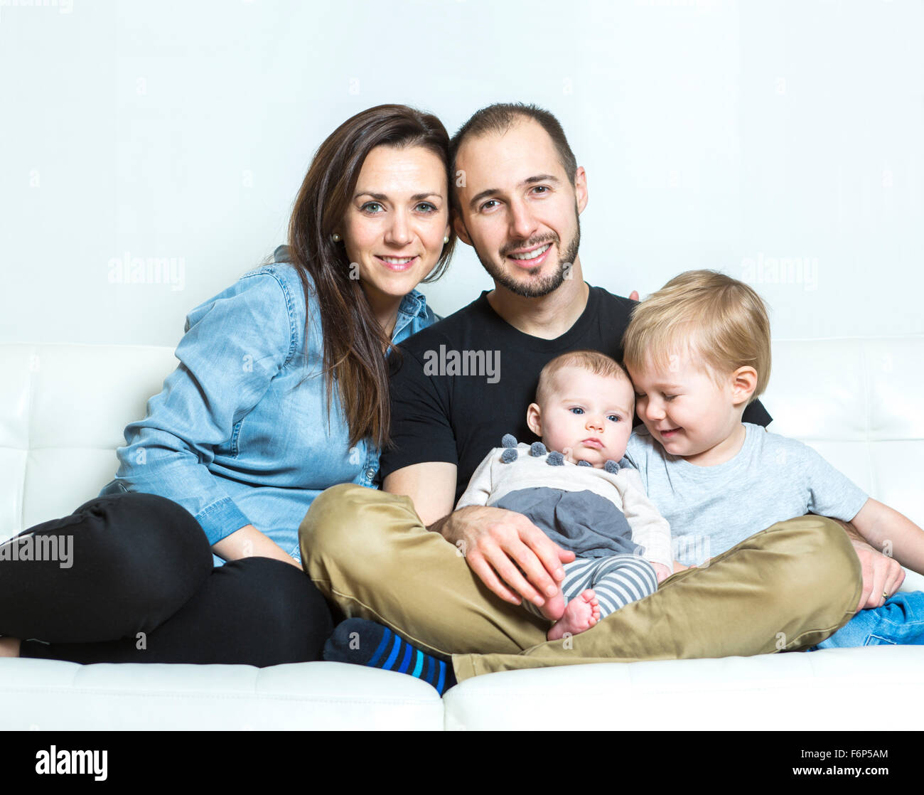 Young happy family with two children at home Stock Photo - Alamy