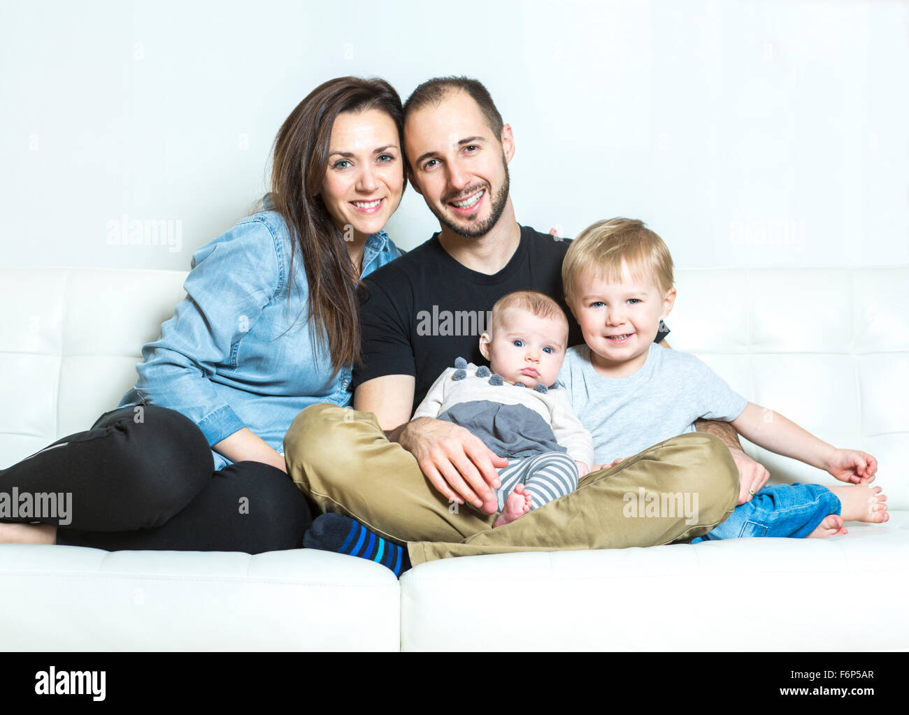 Young happy family with two children at home Stock Photo - Alamy