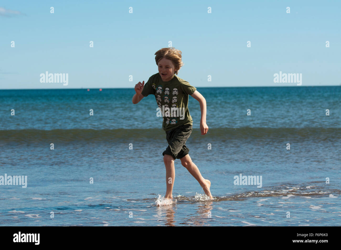 Boy running in sea Stock Photo - Alamy