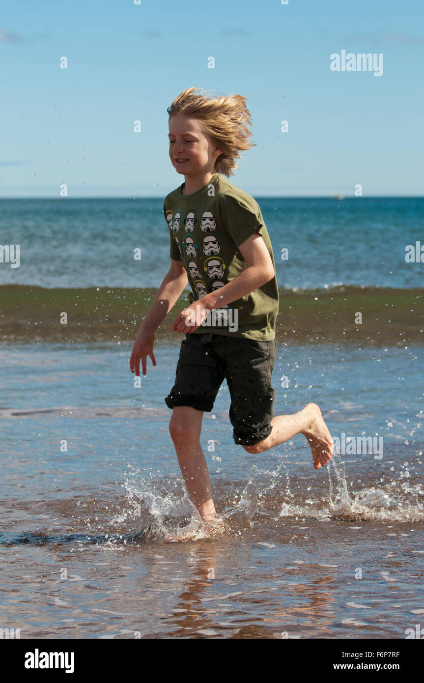 Boy running in sea Stock Photo - Alamy