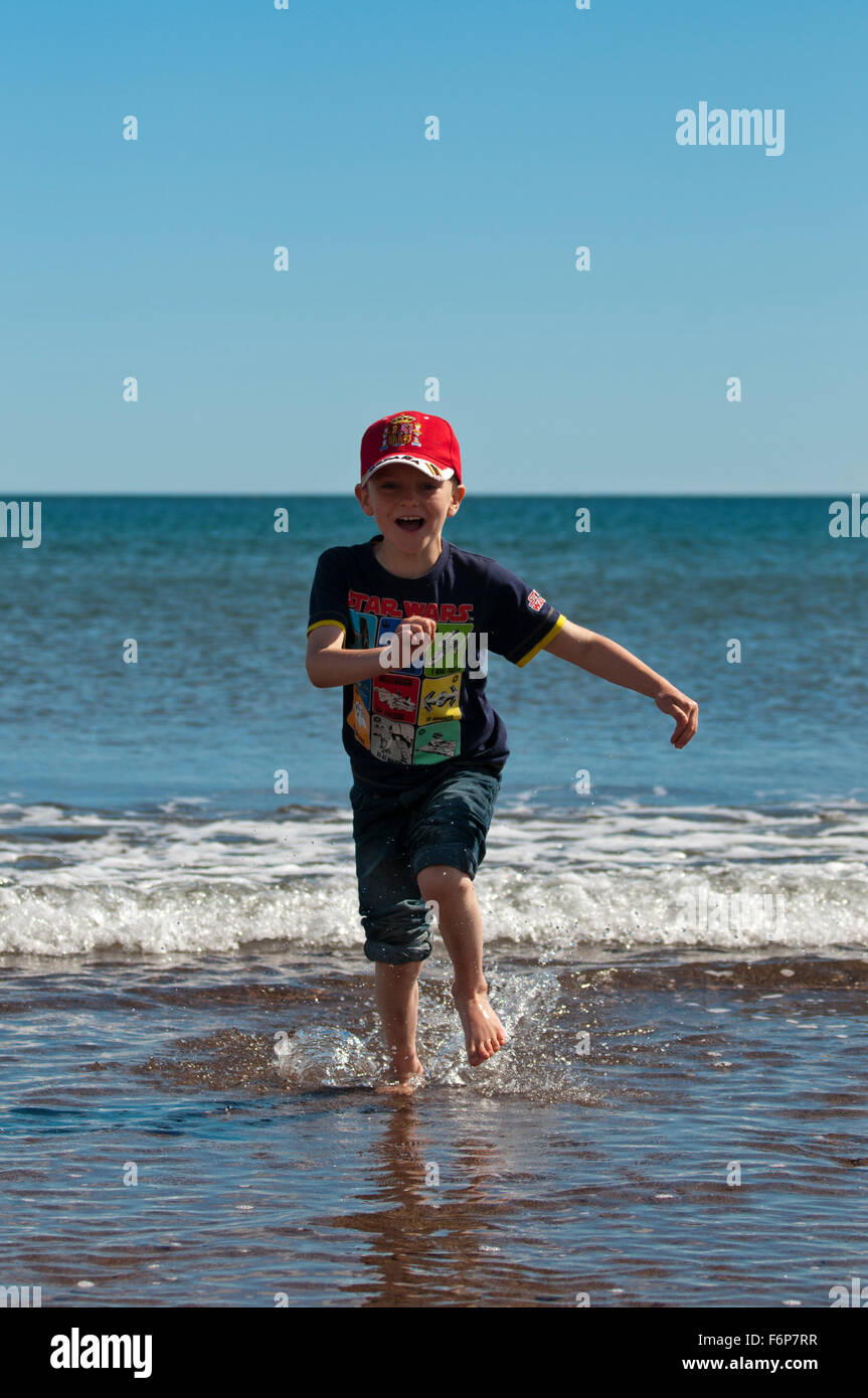 Boy running in sea Stock Photo - Alamy