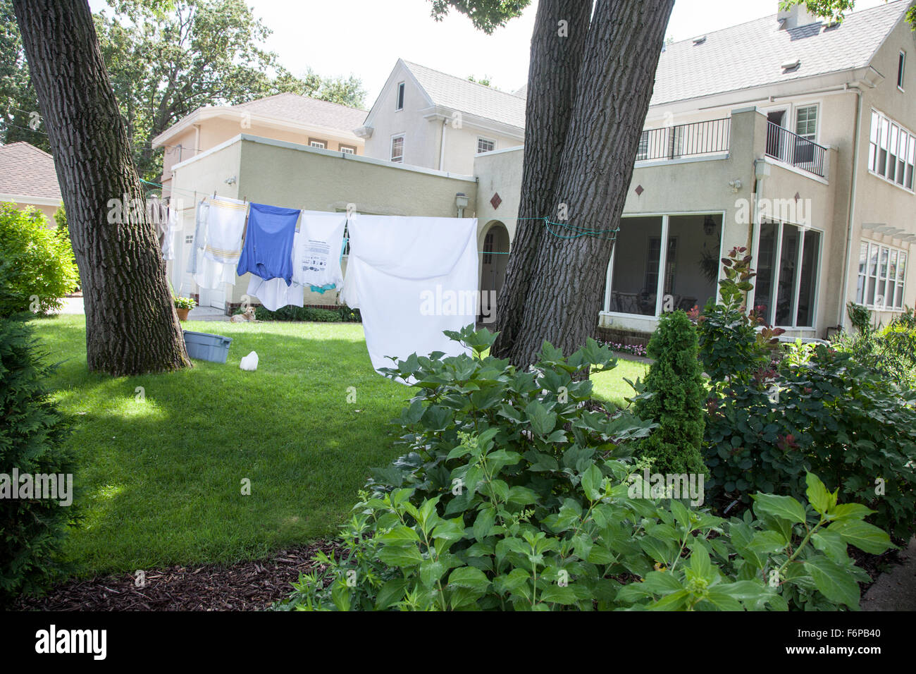 Environmentally conscious neighbor hanging laundry on clothes line to ...