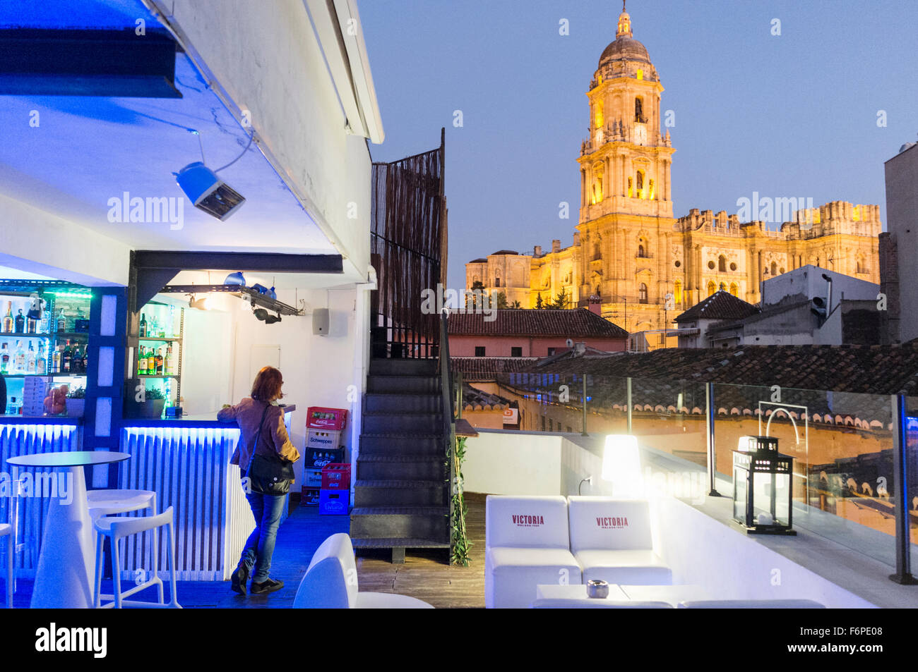 Woman at Chinitas Urban Hostel rooftop terrace bar with illuminated ...