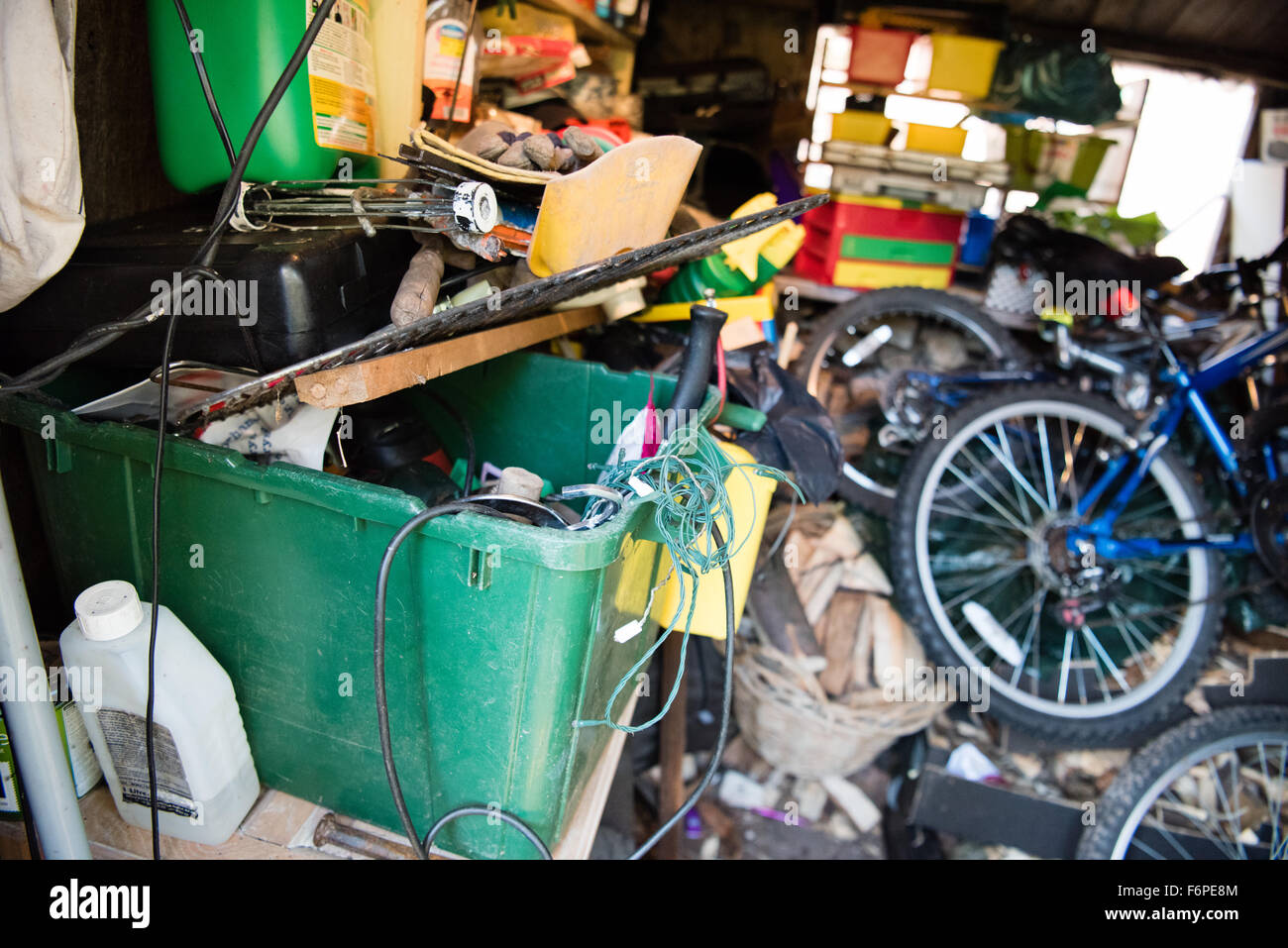 Inside a messy and cluttered wooden garage shed with tools, bikes and ...