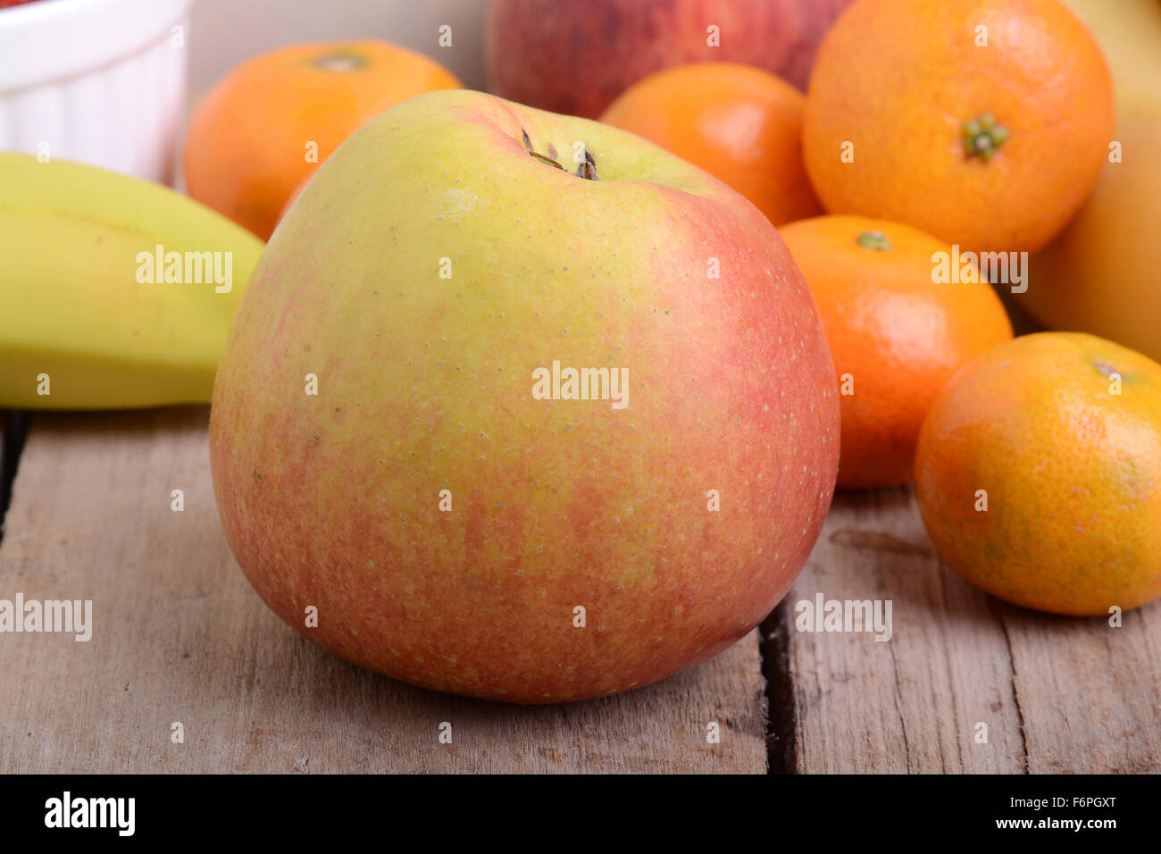 Bananas apple mandarin peach strawberry on wooden background as health ...