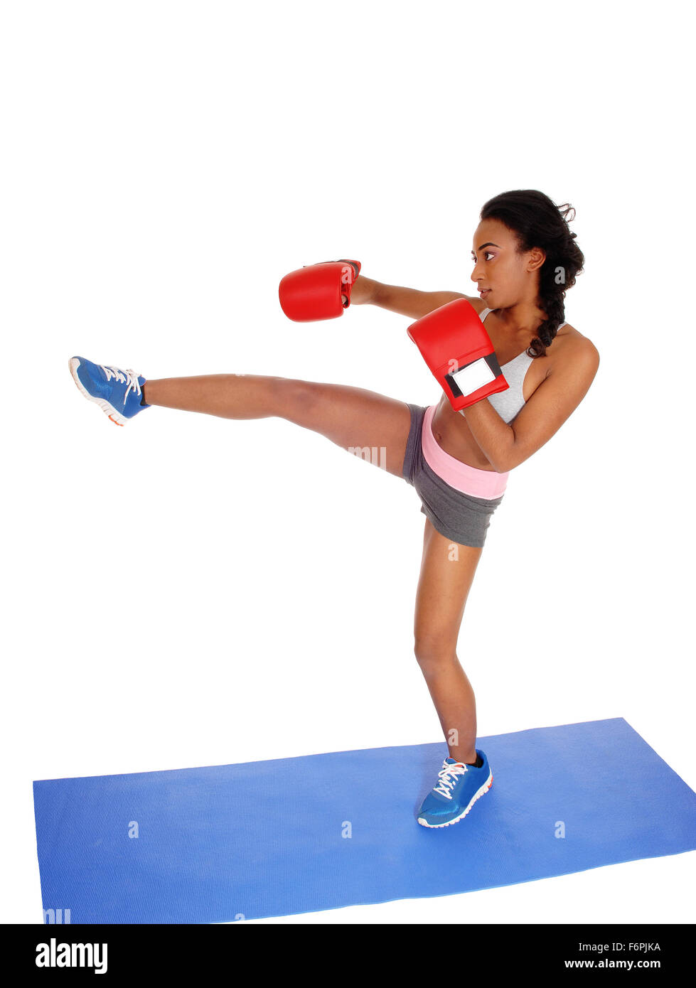 A slim african american girl standing on a blue mat during boxing ...
