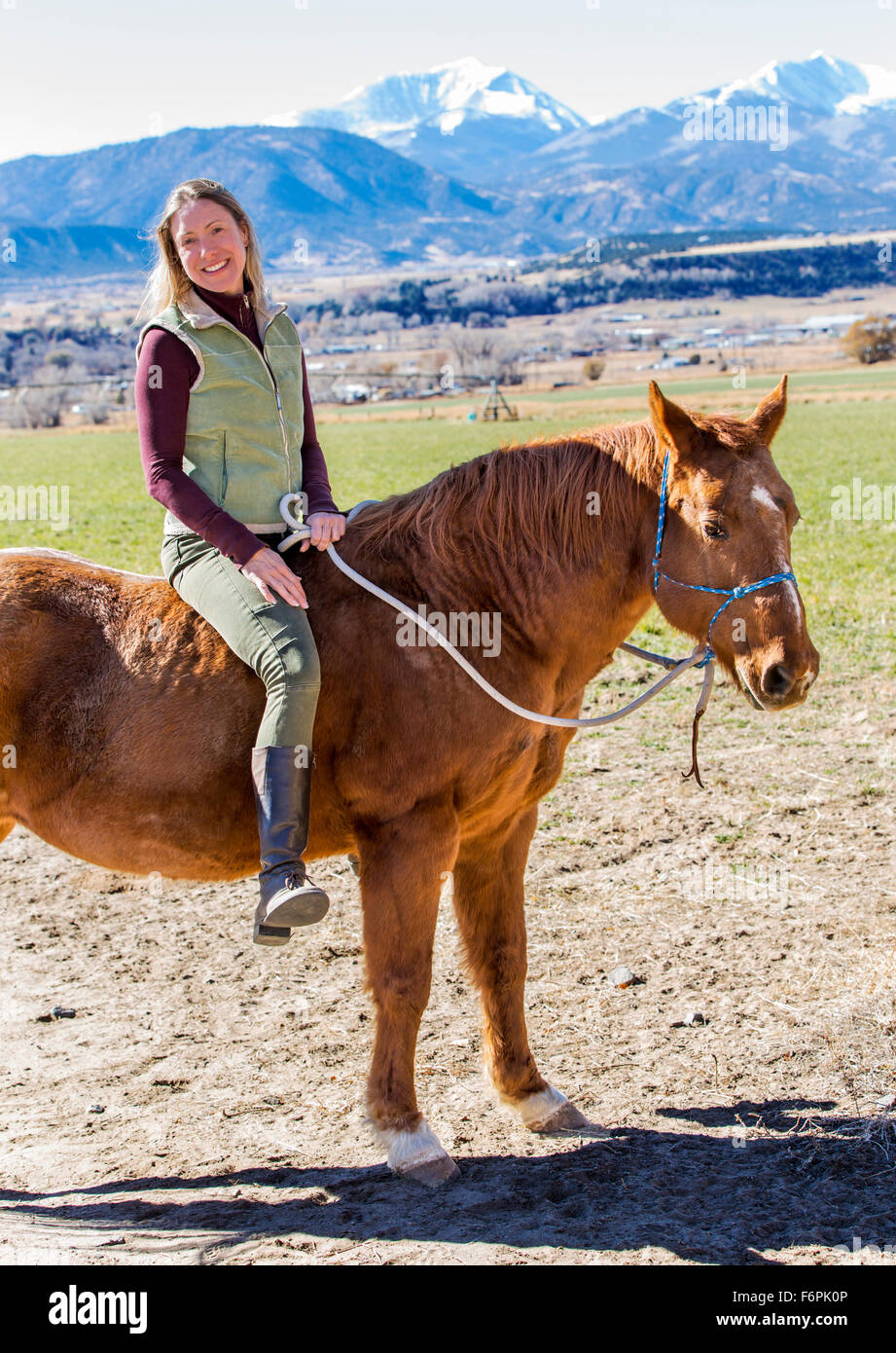 Attractive woman riding horse bareback in ranch pasture with Rocky ...