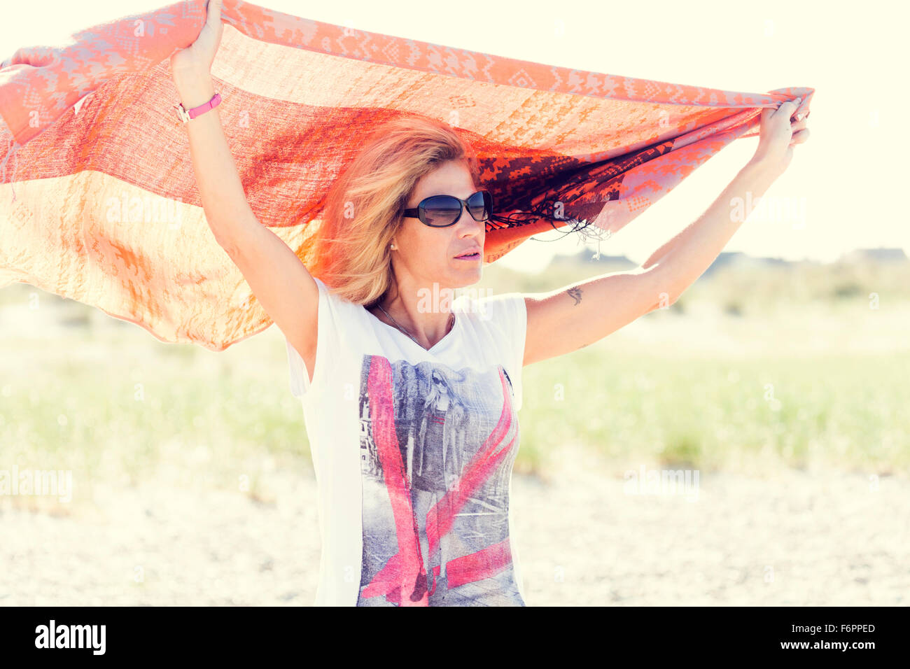 woman holding scarf blowing in the wind Stock Photo - Alamy