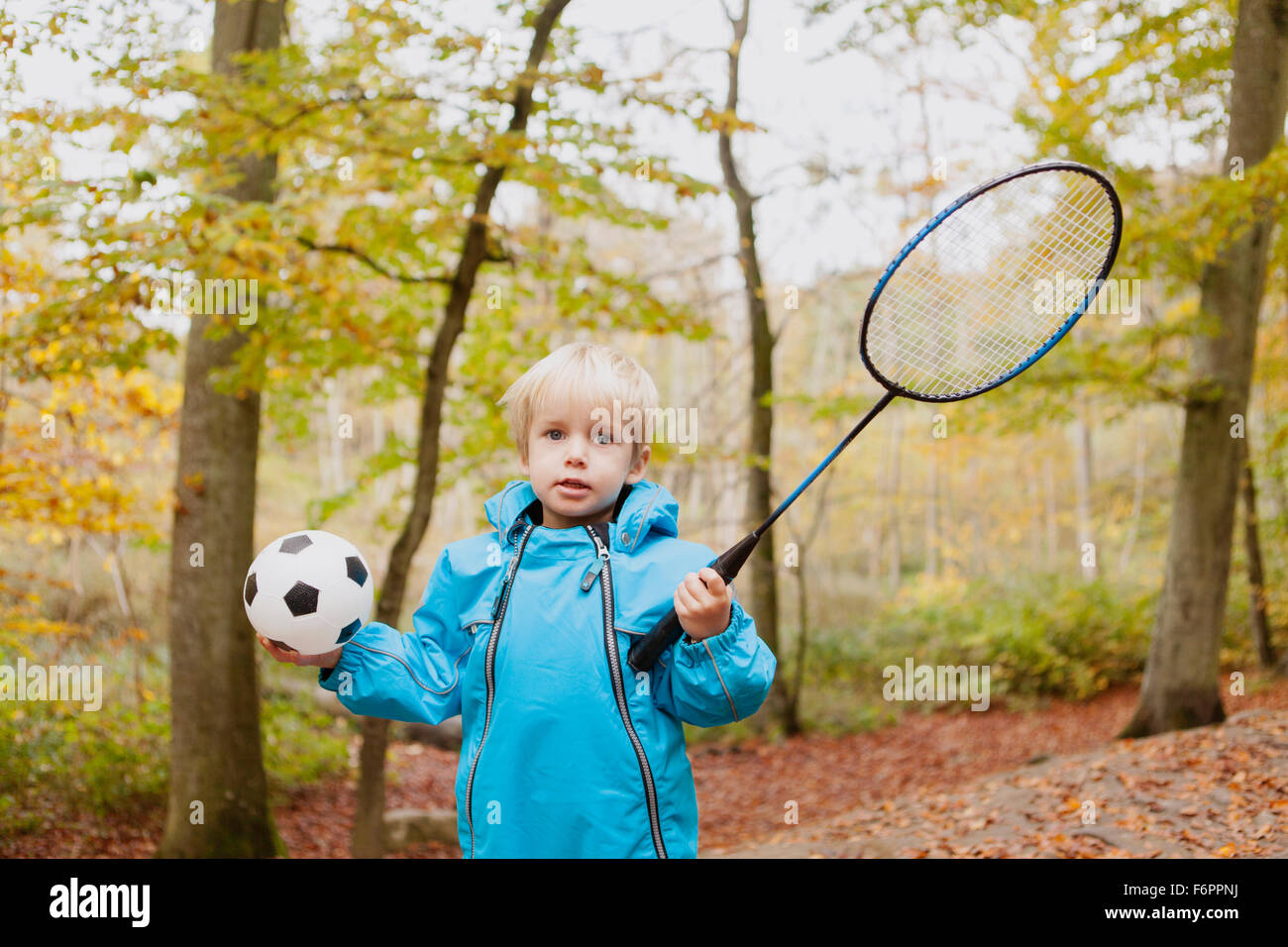 Portrait of boy holding badminton racket and ball in park Stock Photo ...