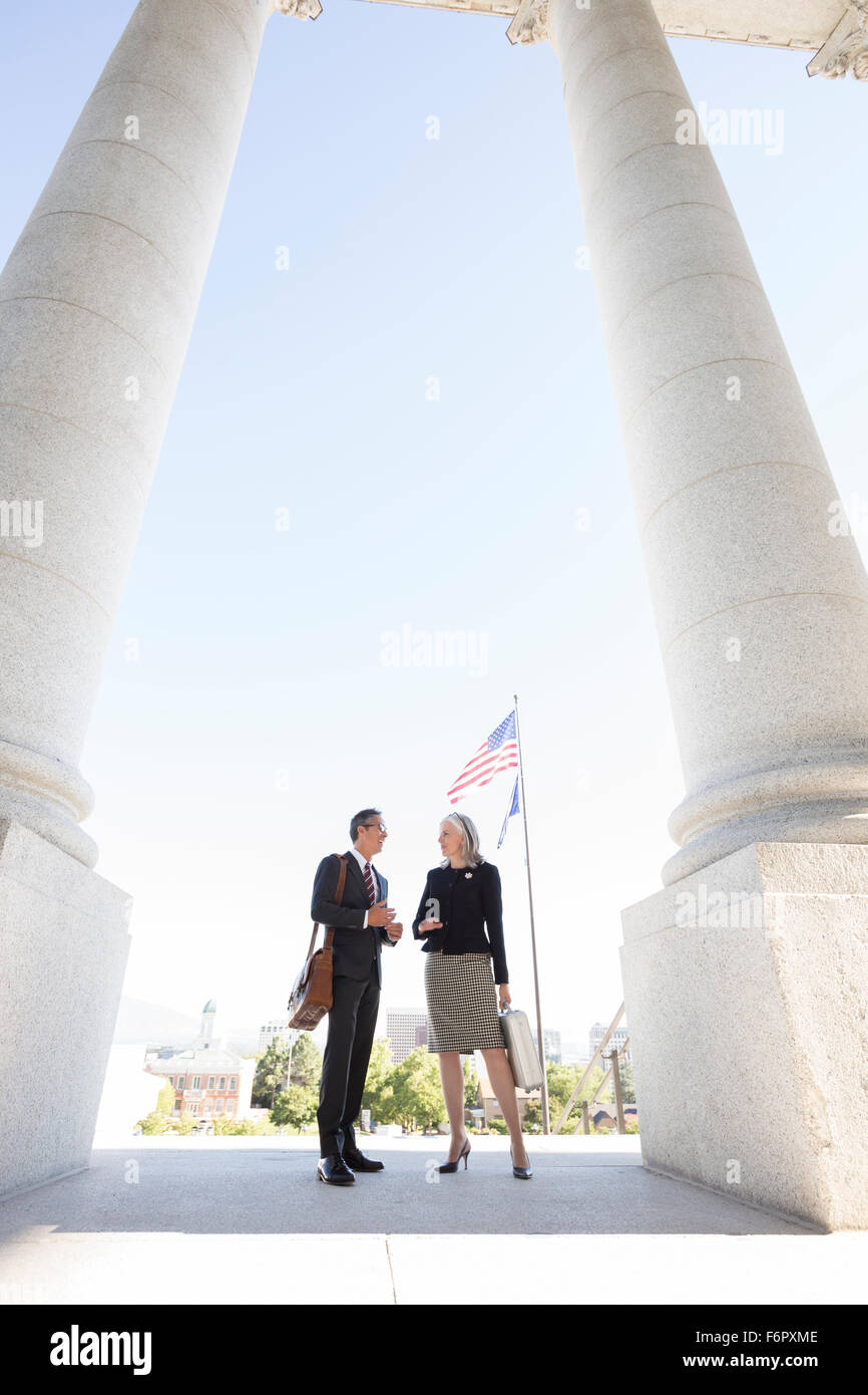 Business people talking under columns Stock Photo - Alamy