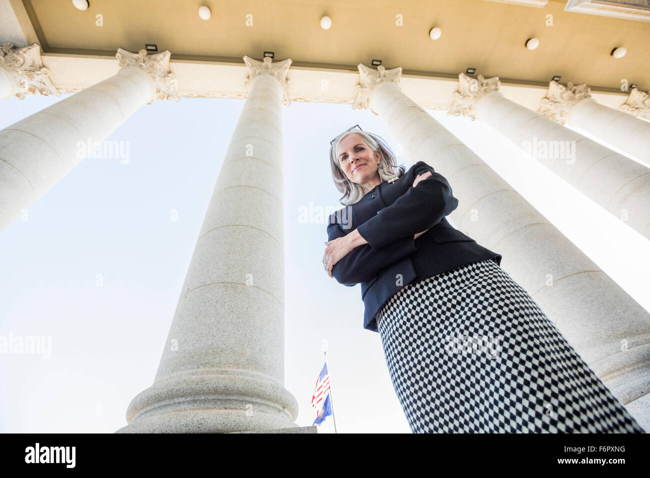 Low angle view of woman standing with her arms crossed hi-res stock ...