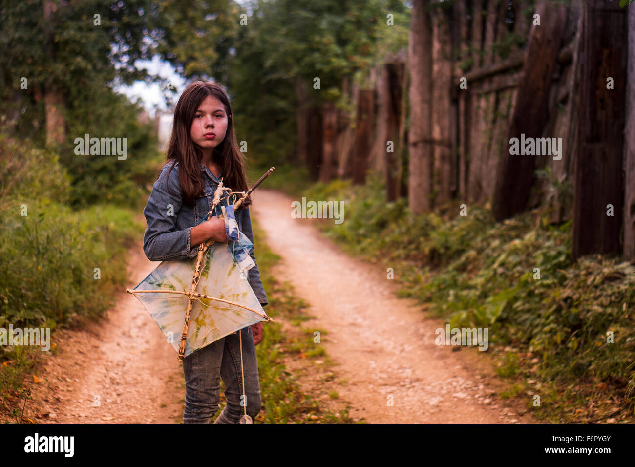Caucasian teenage girl carrying kite on dirt road Stock Photo - Alamy