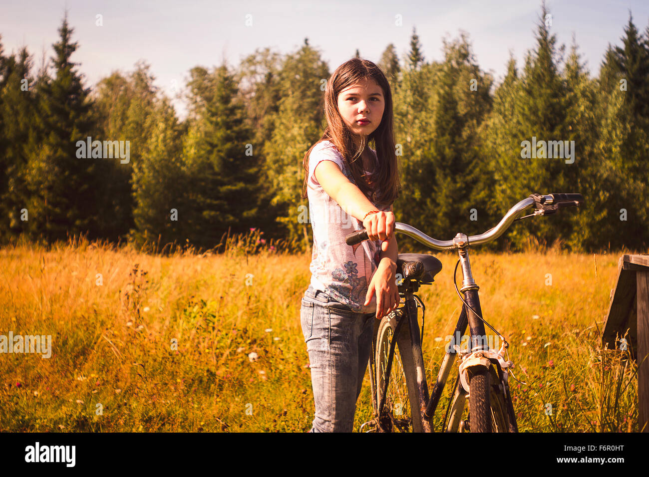 Caucasian teenage girl pushing bicycle in field Stock Photo - Alamy