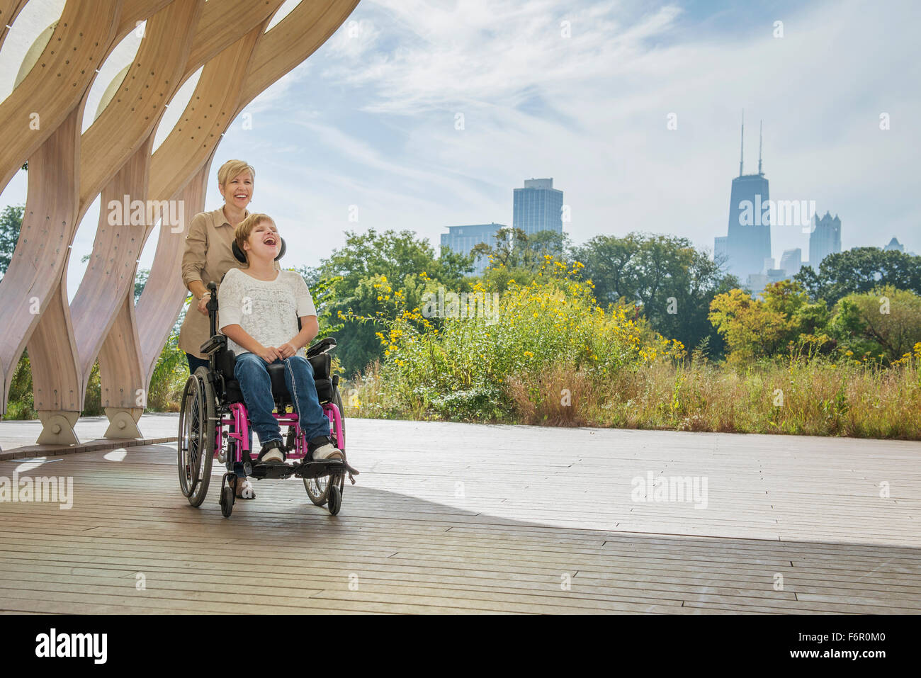Mother pushing paraplegic daughter in wheelchair Stock Photo - Alamy