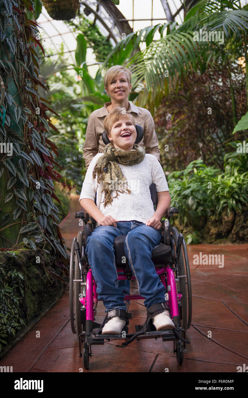 Mother pushing paraplegic daughter in wheelchair Stock Photo - Alamy