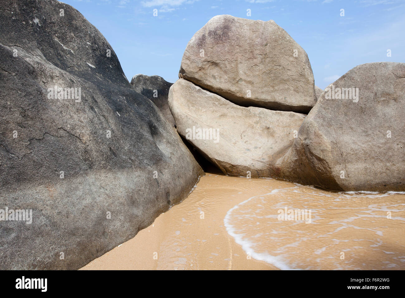 Natural rock formations on a tropical sandy beach, wetahered by the sea ...