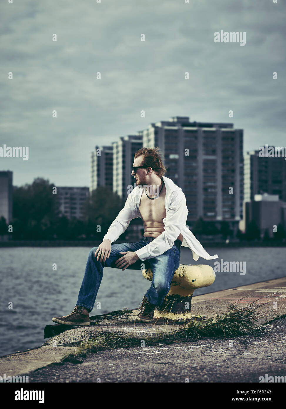 Handsome man wearing white shirt and jeans, windy day in harbour Stock ...