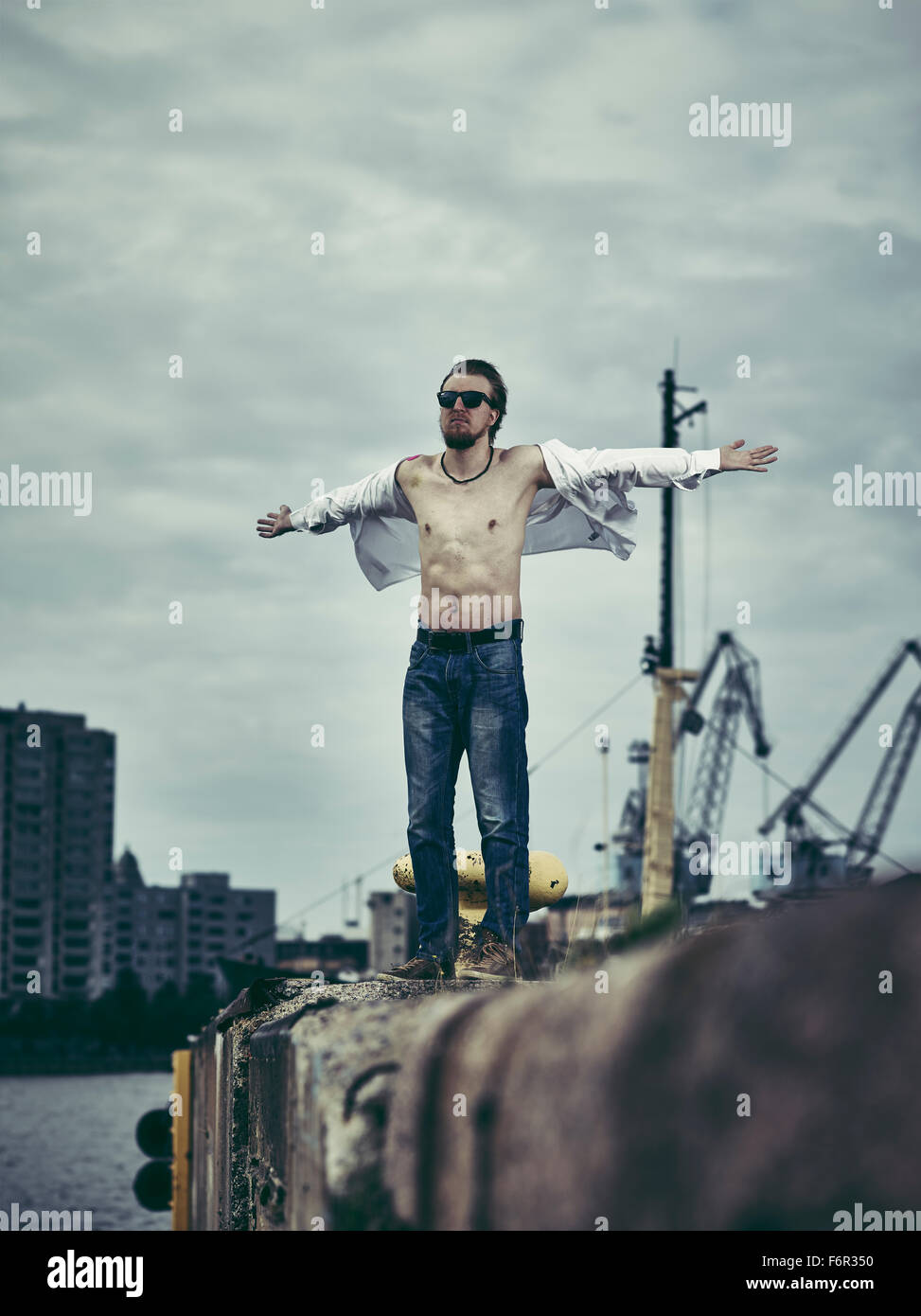Handsome man wearing white shirt and jeans, windy day in harbour Stock ...