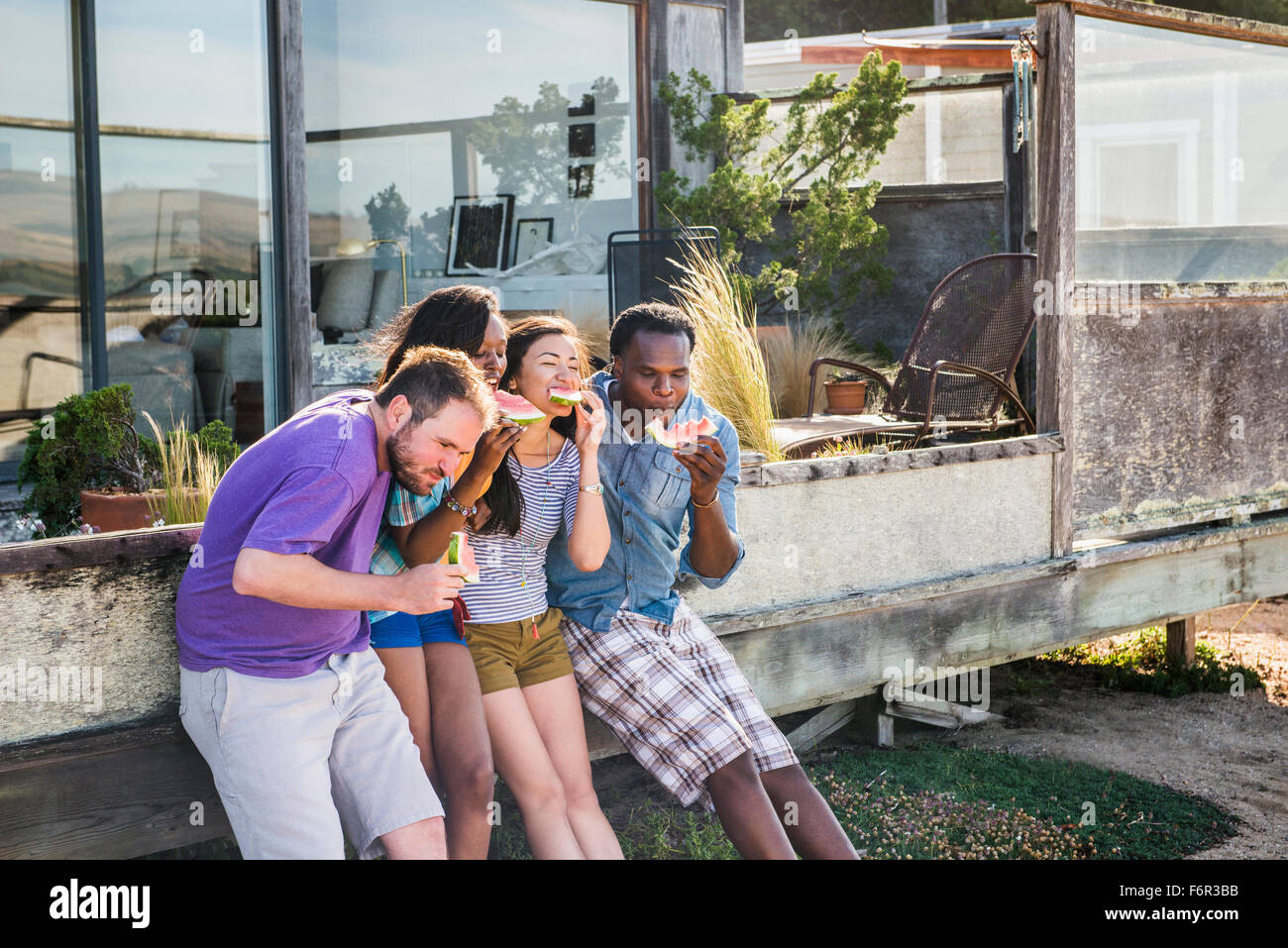 Friends eating watermelon in backyard Stock Photo - Alamy