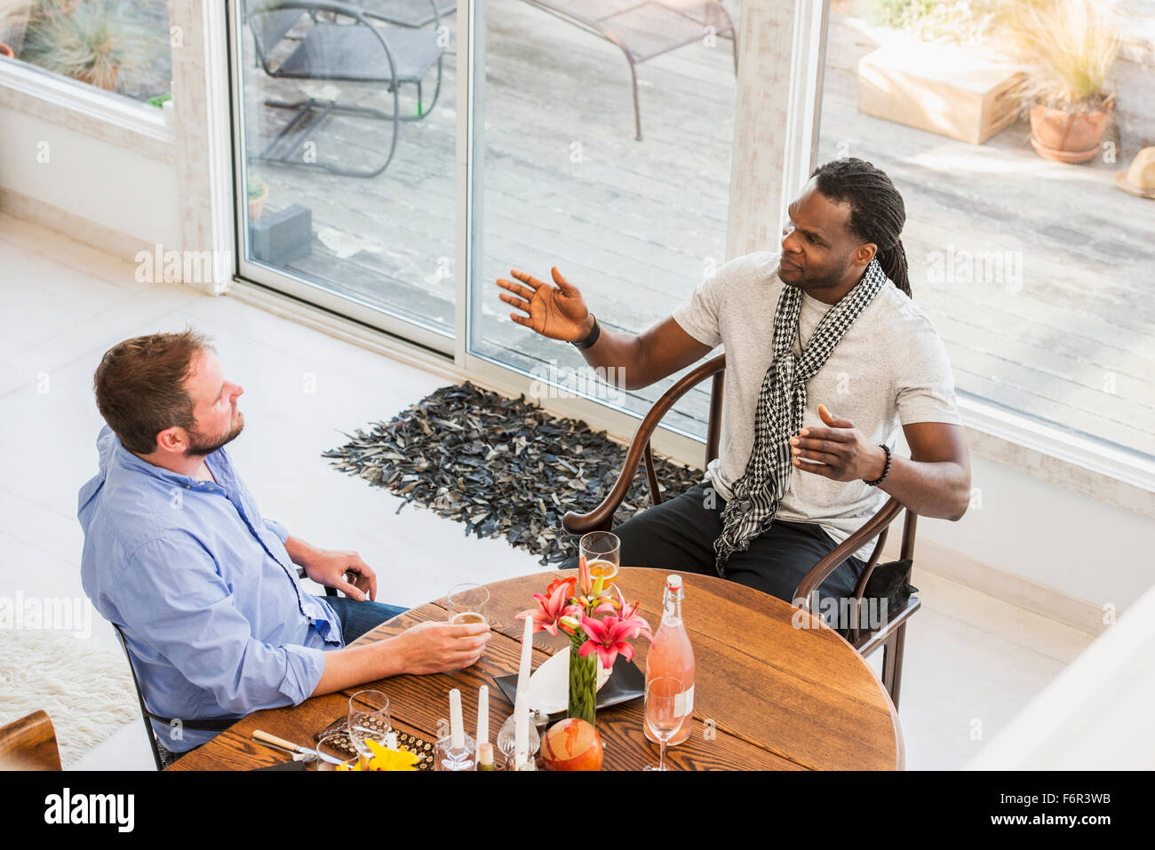 Men talking at dining room table Stock Photo - Alamy
