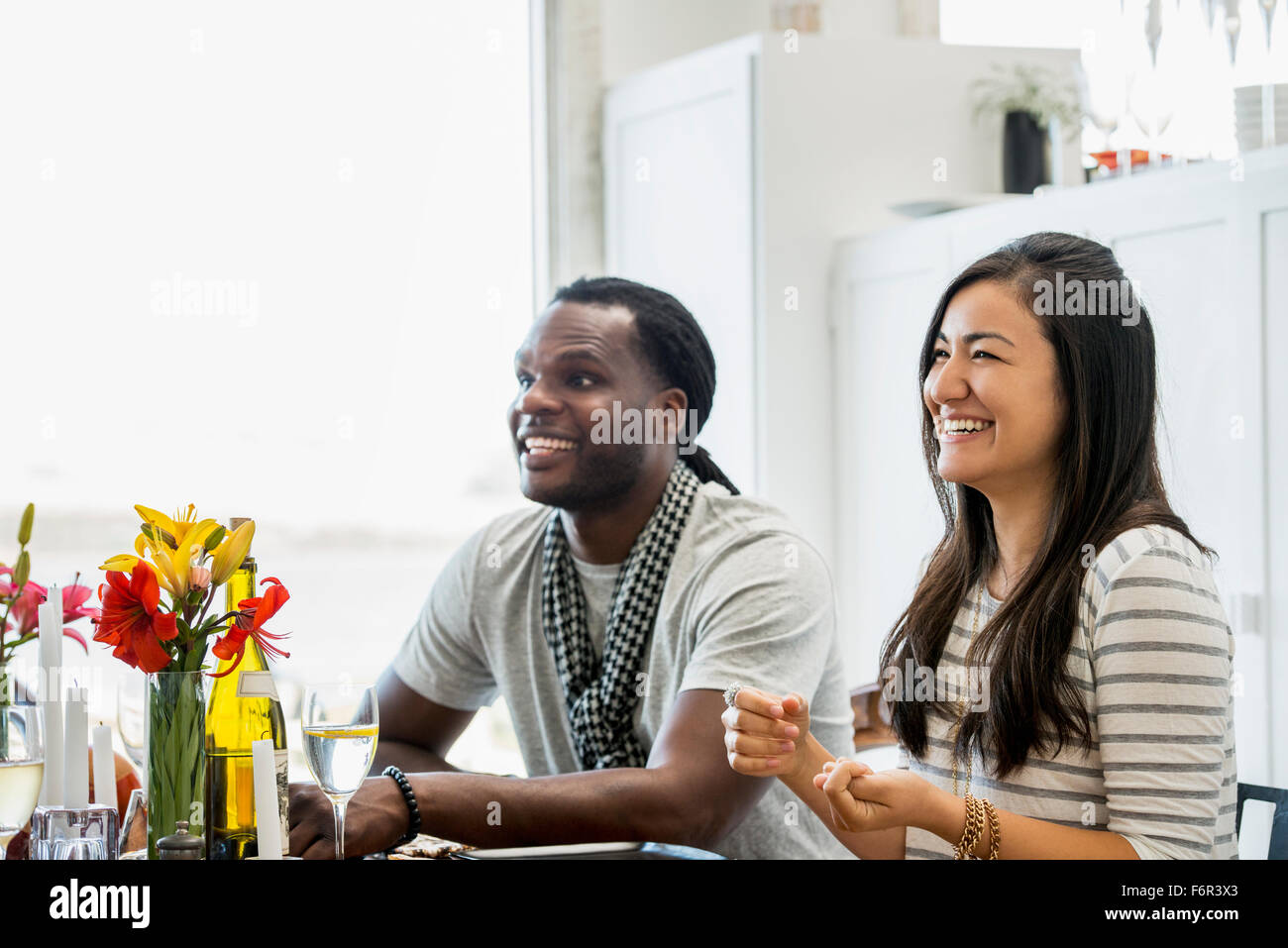 Couple smiling at dining room table Stock Photo - Alamy