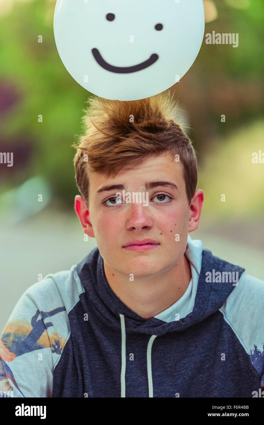 Sad Caucasian teenage boy balancing balloon Stock Photo - Alamy