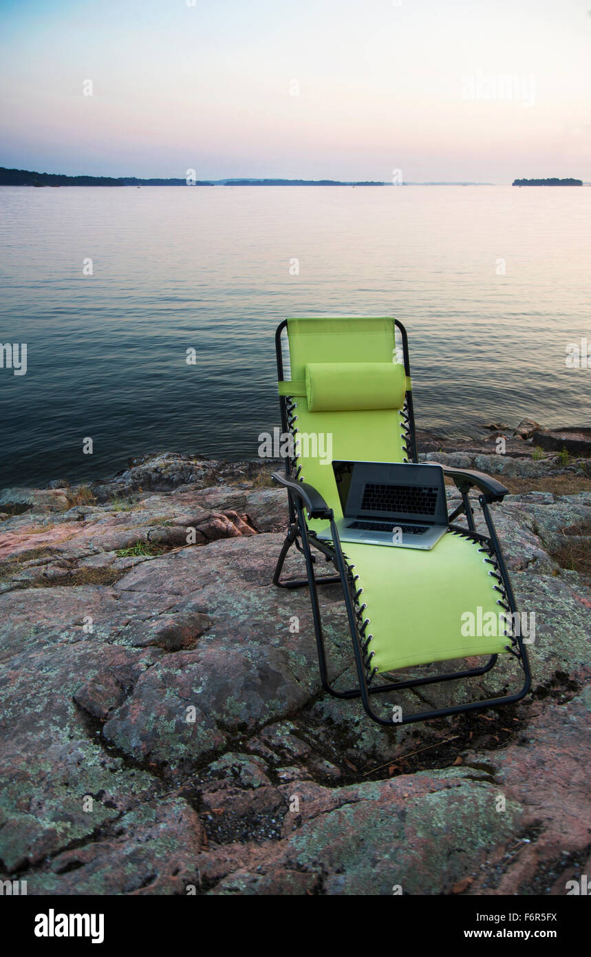 Laptop on lawn chair near remote river Stock Photo - Alamy