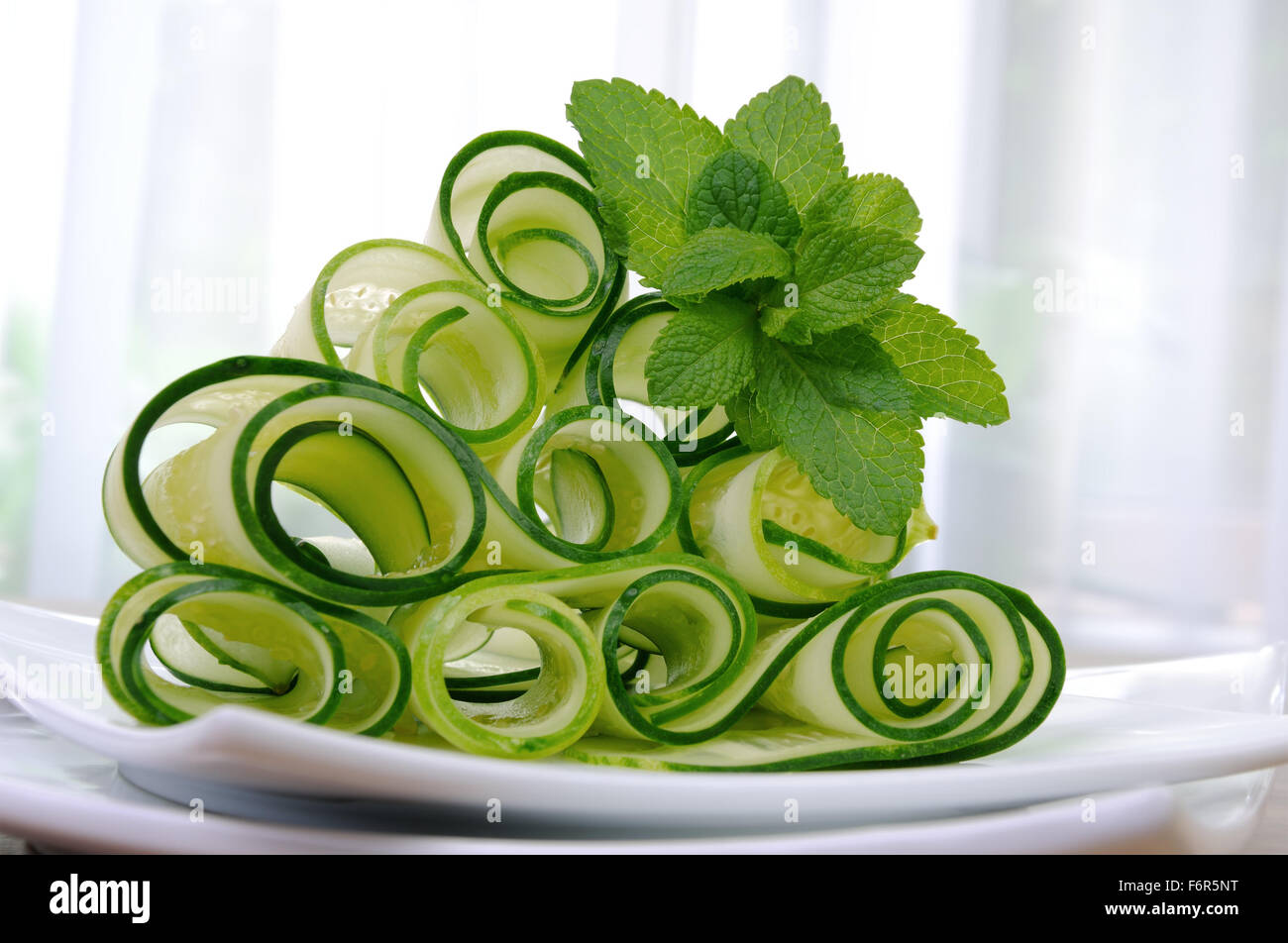 Salad cucumber ribbons twisted in rolls with mint Stock Photo - Alamy