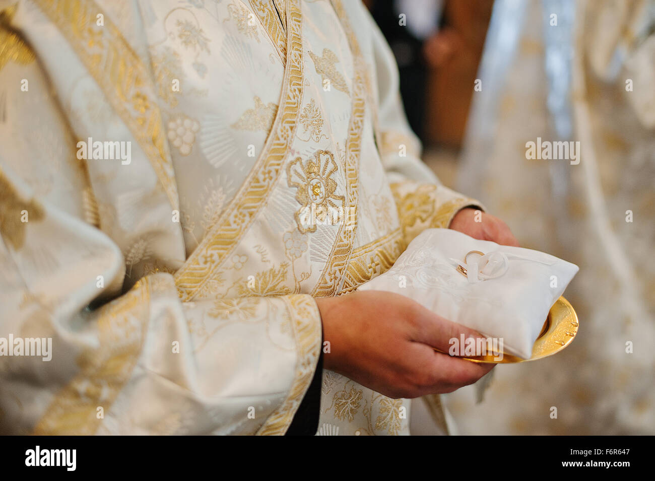 wedding rings at hand of priest Stock Photo - Alamy