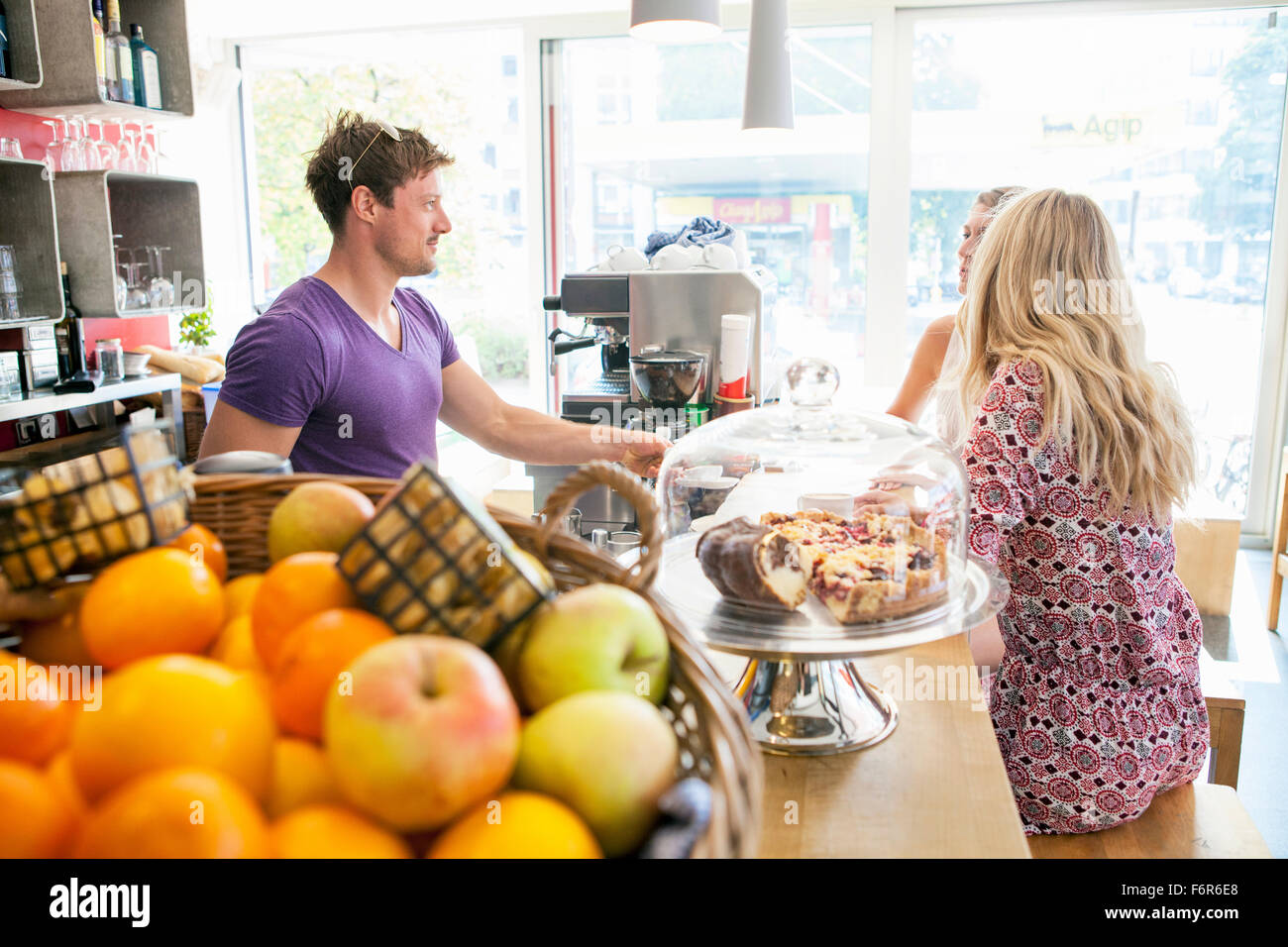 Group of friends at counter in restaurant Stock Photo - Alamy