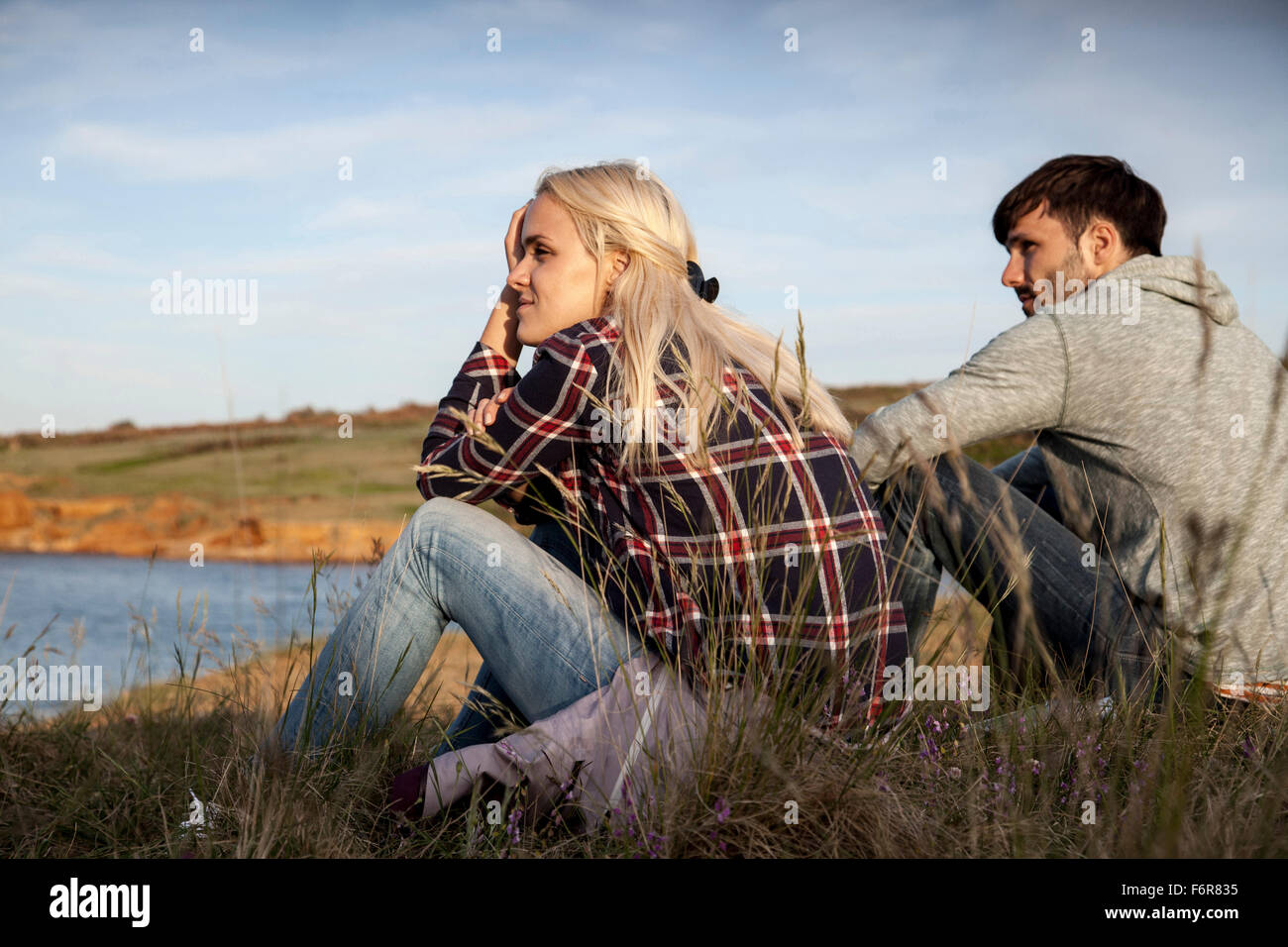 Couple sitting on edge cliff hi-res stock photography and images - Alamy