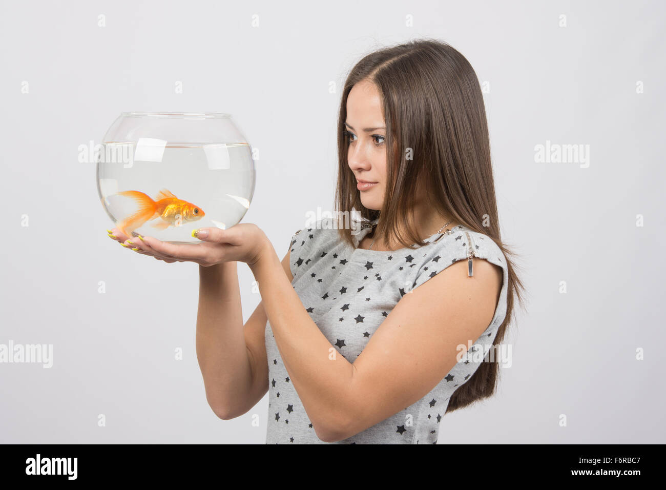 Young happy woman holds a fishbowl with a goldfish Stock Photo - Alamy