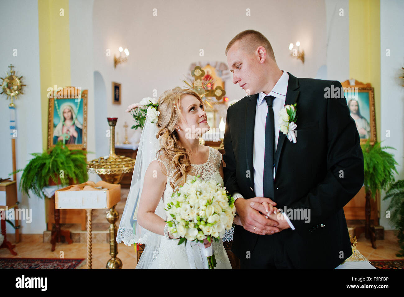 wedding couple stay at church and looked each other Stock Photo - Alamy